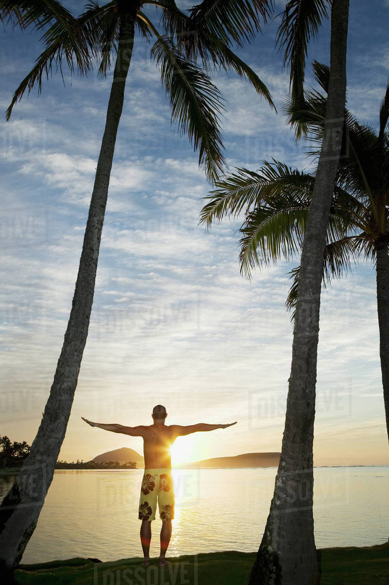 Asian man watching sunset - Stock Photo - Dissolve
