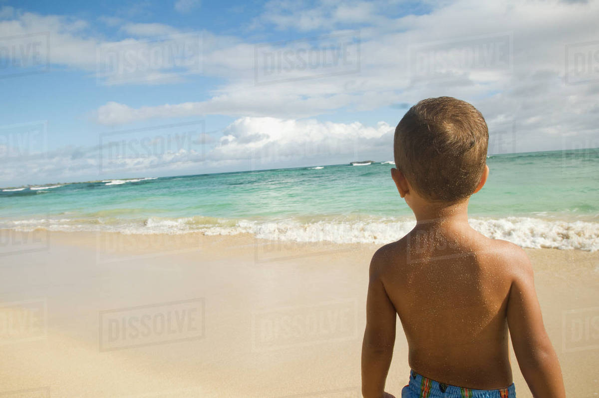 Pacific Islander boy looking at ocean - Royalty-free Stock Photo | Dissolve