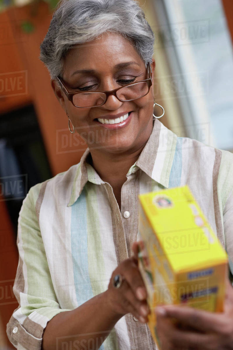 African woman reading food ingredients - Stock Photo - Dissolve