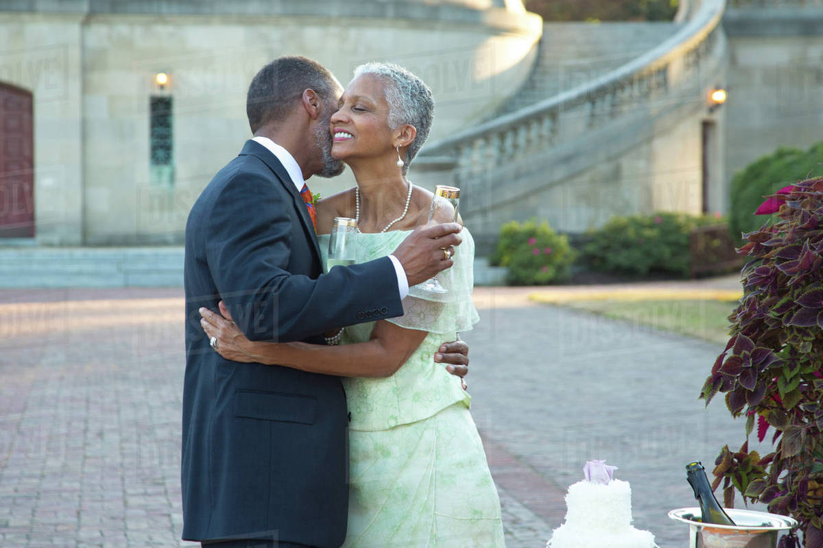 Couple hugging near wedding cake - Royalty-free Stock Photo | Dissolve