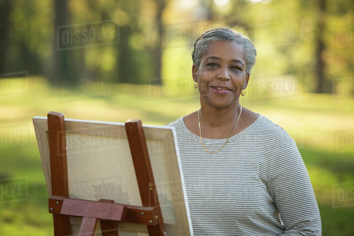 Portrait of woman painting on canvas in park - Royalty-free Stock Photo ...