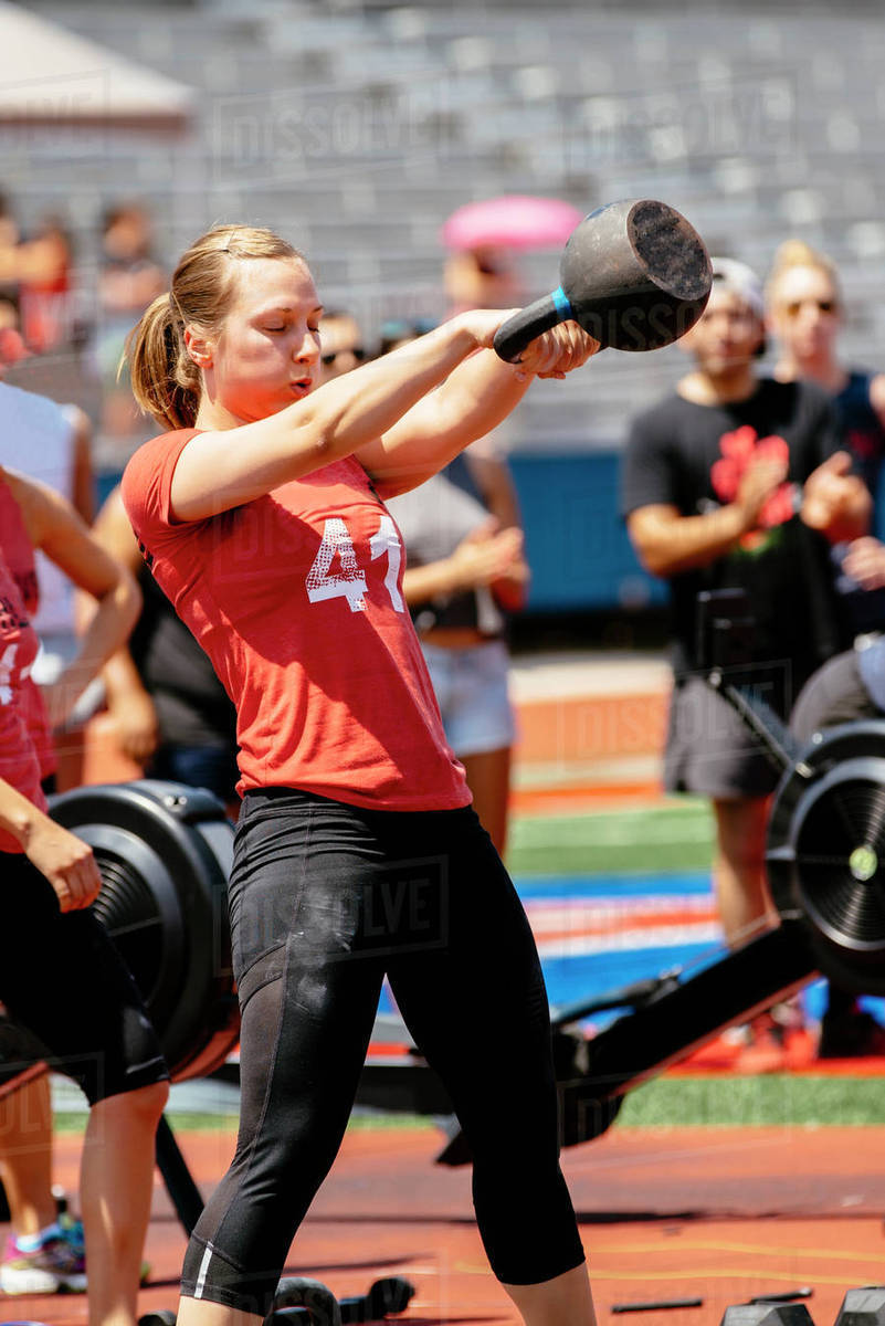 Woman lifting kettlebell outdoors - Royalty-free Stock Photo | Dissolve