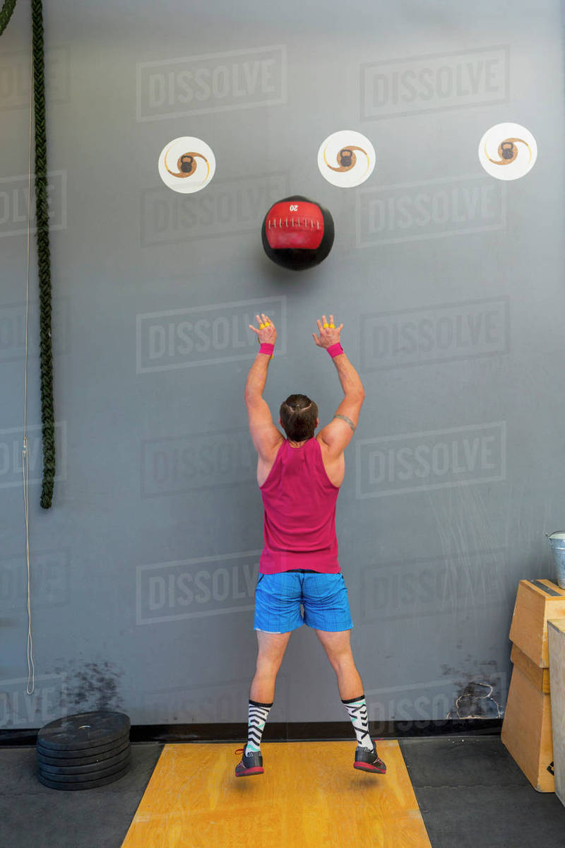 Mixed Race man throwing heavy ball against wall - Royalty-free Stock ...
