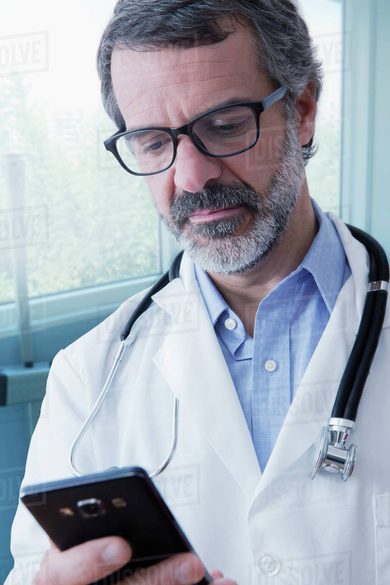 Doctor texting on cell phone - Royalty-free Stock Photo | Dissolve