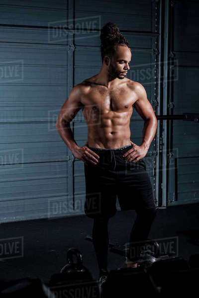 Mixed Race man resting in gymnasium - Stock Photo - Dissolve