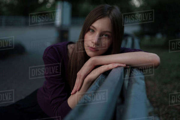 Serious woman leaning on bench - Stock Photo - Dissolve