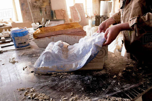 Caucasian artist lifting mold from plaster - Stock Photo - Dissolve