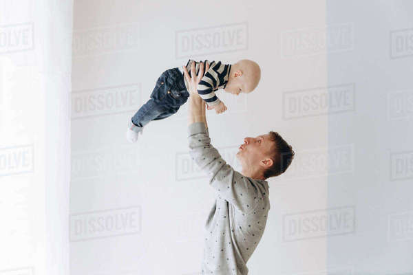 Caucasian father lifting baby son - Royalty-free Stock Photo | Dissolve
