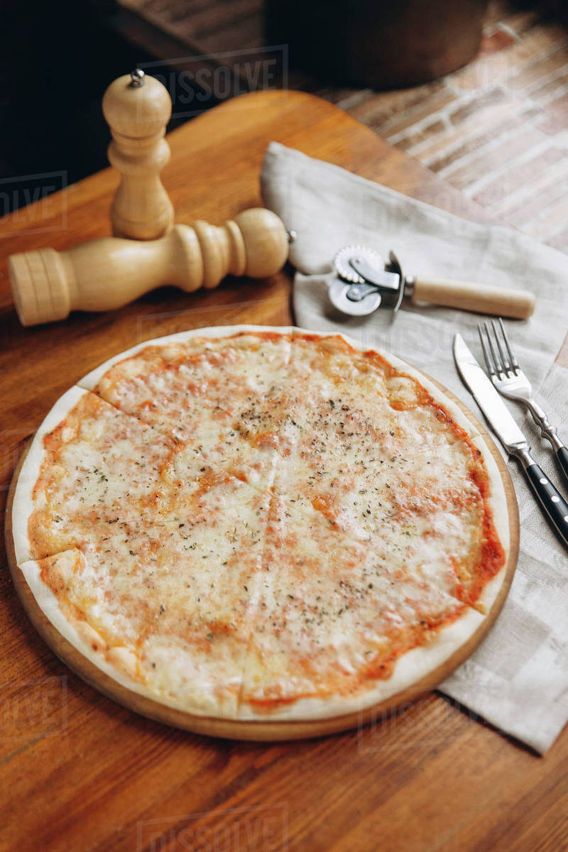Pizza pie on table - Royalty-free Stock Photo | Dissolve