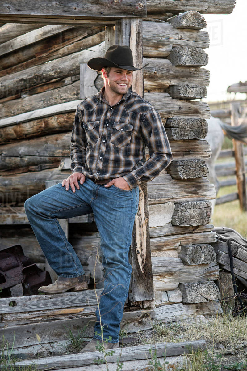 Caucasian cowboy leaning in doorway of cabin - Stock Photo - Dissolve