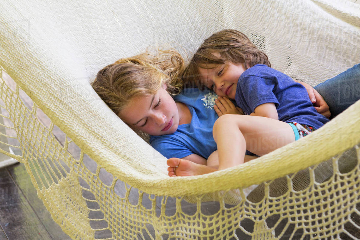 Caucasian brother and sister cuddling in hammock - Royalty-free Stock ...
