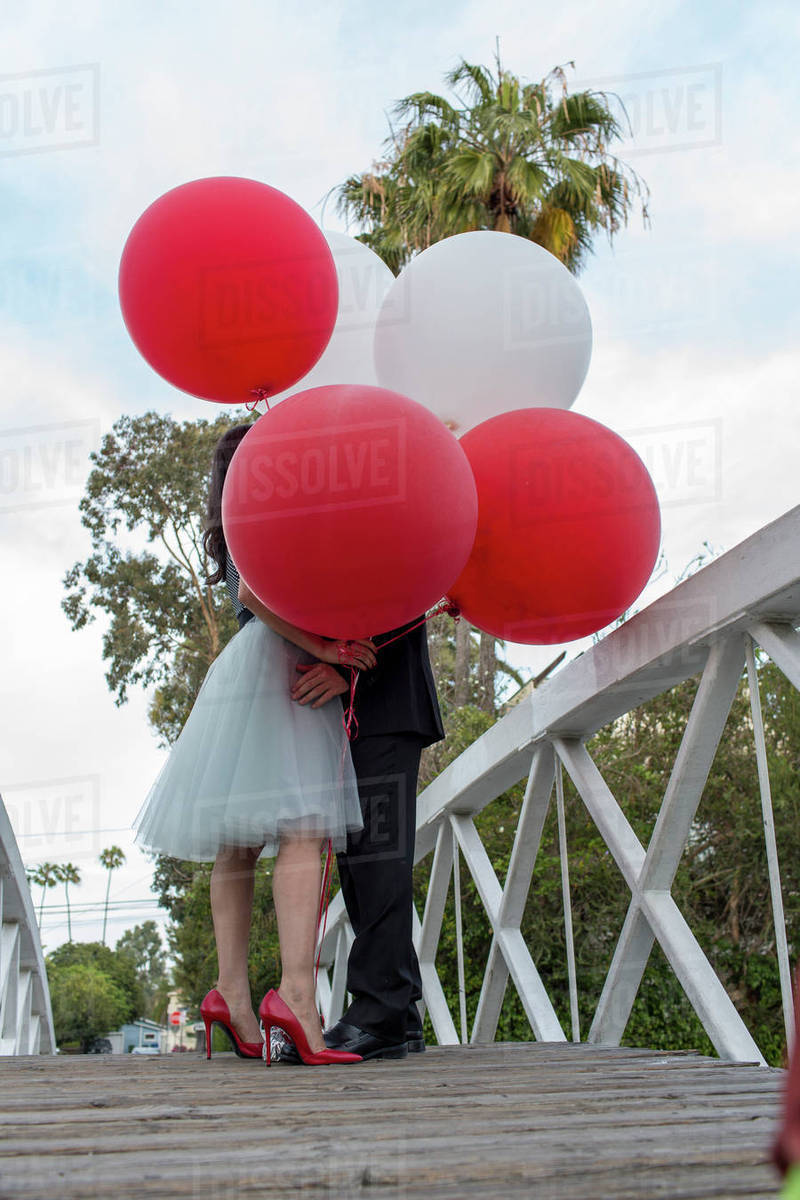 Couple on bridge kissing behind balloons - Royalty-free Stock Photo ...