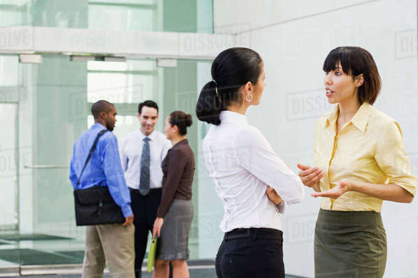 Business people talking in lobby - Royalty-free Stock Photo | Dissolve
