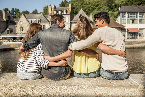 Friends sitting and hugging at waterfront - Royalty-free Stock Photo ...