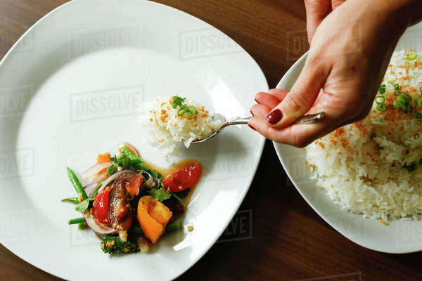 Hands of woman serving rice - Royalty-free Stock Photo | Dissolve