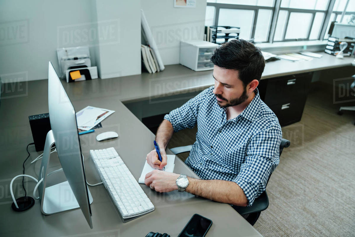 Caucasian businessman writing notes at a computer - Royalty-free Stock ...