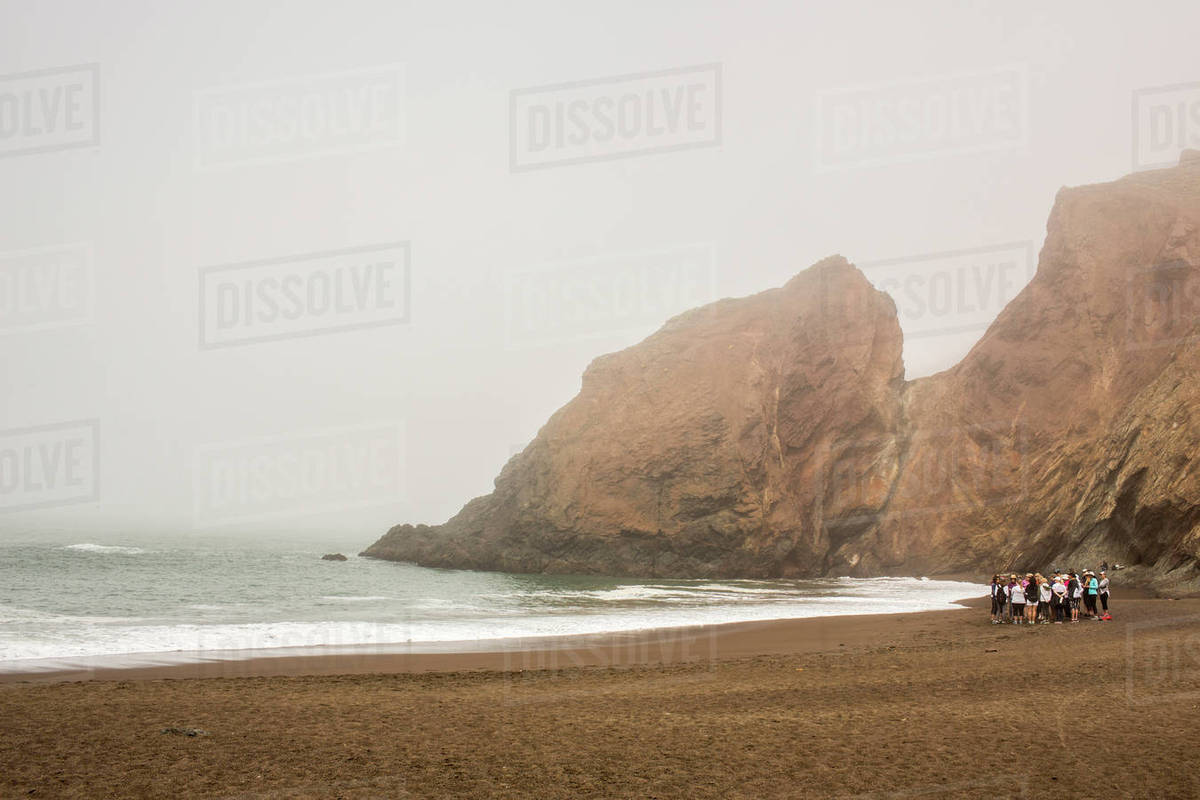 Distant crowd of people standing on beach - Stock Photo - Dissolve