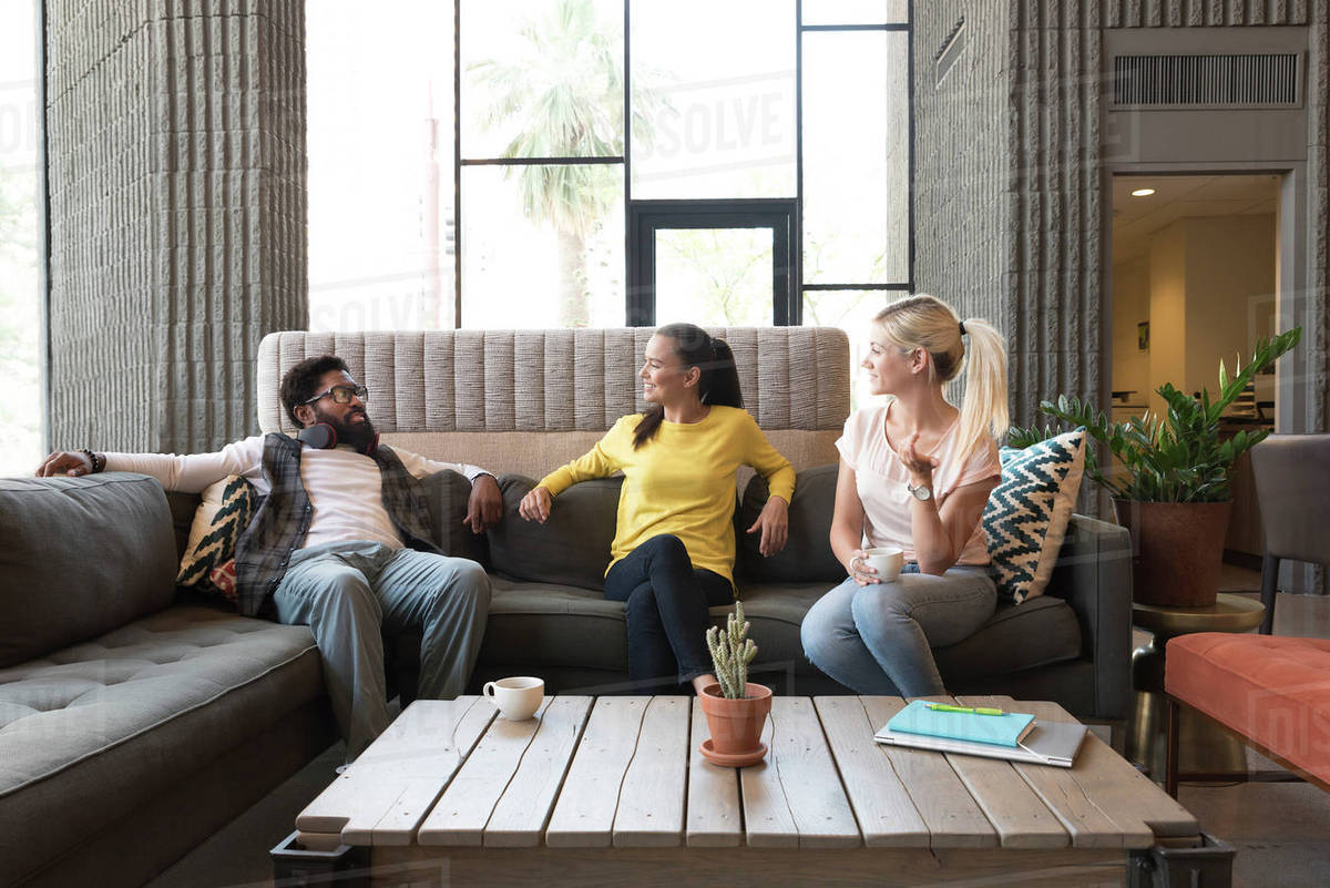 Friends talking in lounge - Stock Photo - Dissolve