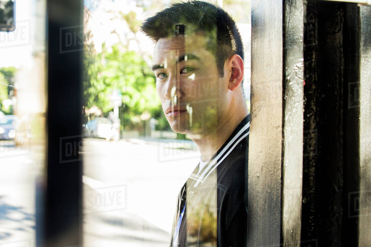 Serious Chinese man behind window - Stock Photo - Dissolve