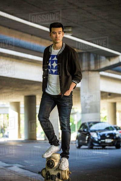 Serious Chinese man standing on hydrant - Royalty-free Stock Photo ...