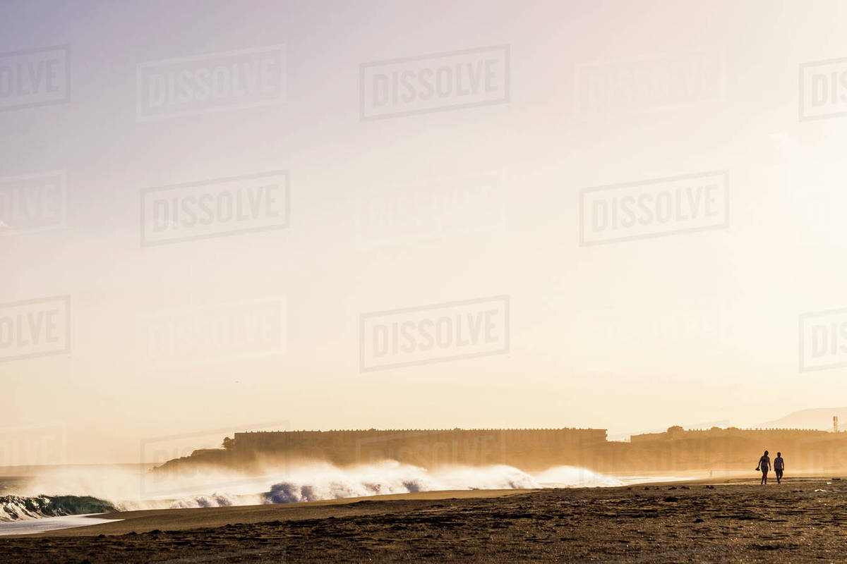 Distant people walking on beach - Royalty-free Stock Photo | Dissolve