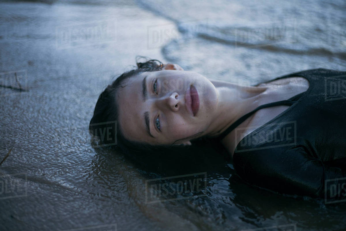 Caucasian woman laying on beach in waves - Royalty-free Stock Photo ...