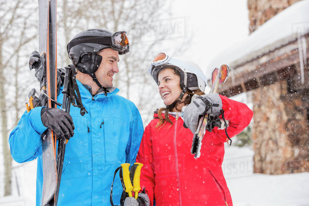 Smiling Caucasian couple carrying skis - Royalty-free Stock Photo ...