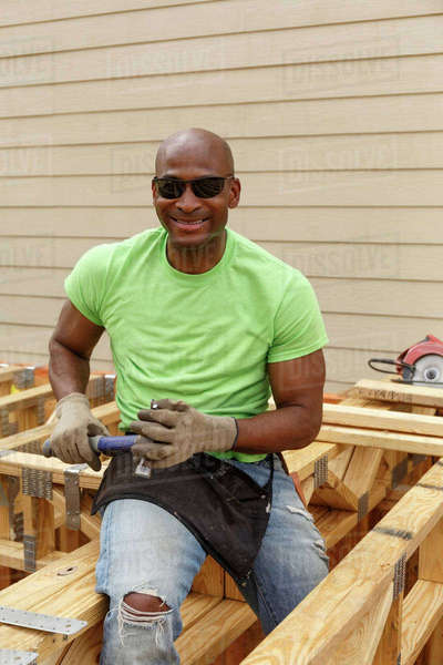Black man posing with hammer at construction site - Royalty-free Stock ...