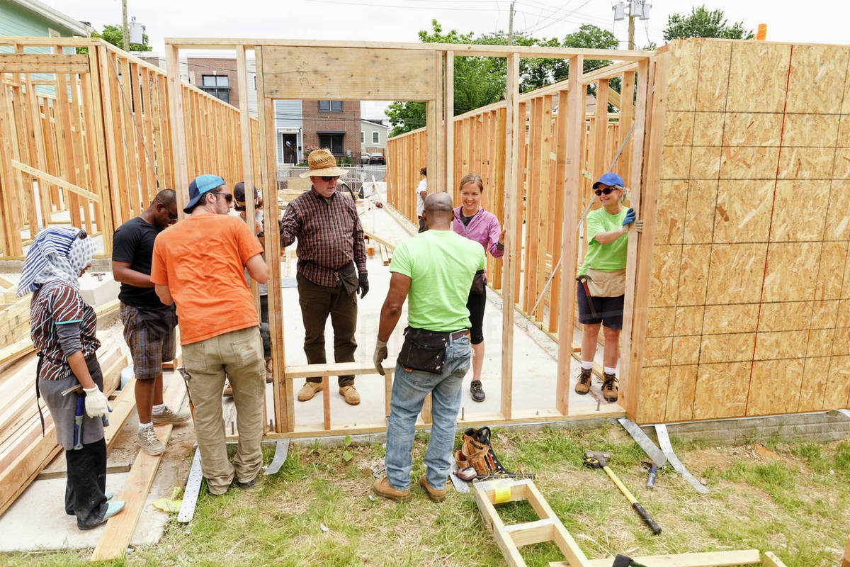 Volunteers holding wall at construction site - Royalty-free Stock Photo ...