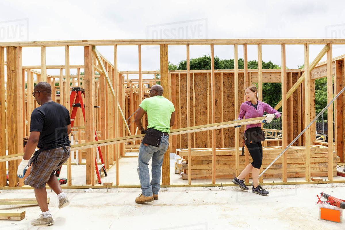 Volunteers carrying lumber at construction site - Royalty-free Stock ...