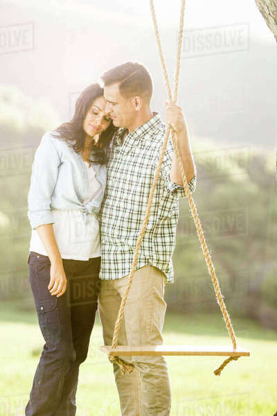 Man hugging woman and holding tree swing - Royalty-free Stock Photo ...