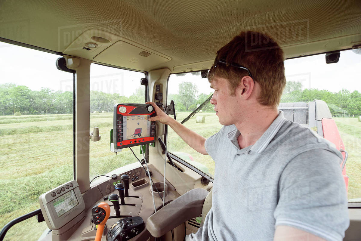 Caucasian man setting control panel in tractor on farm - Stock Photo ...