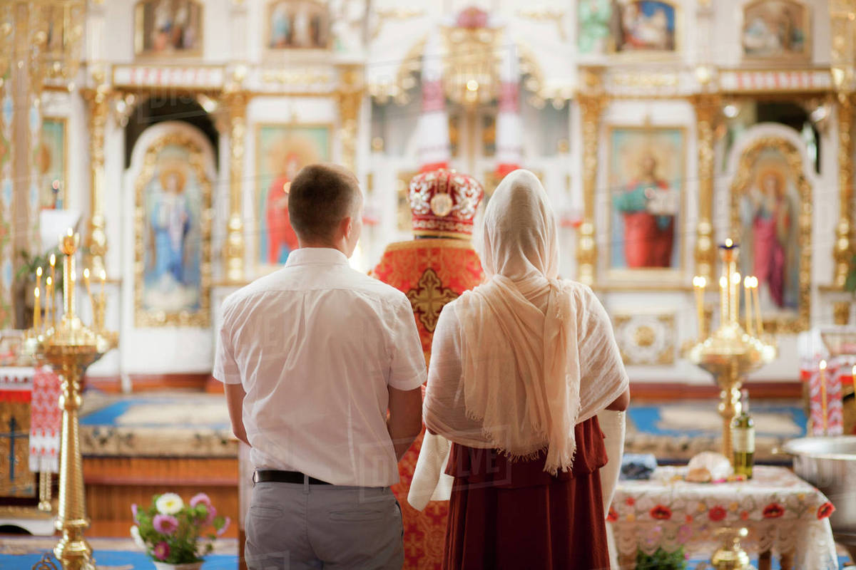 Couple and priest standing in church - Royalty-free Stock Photo | Dissolve