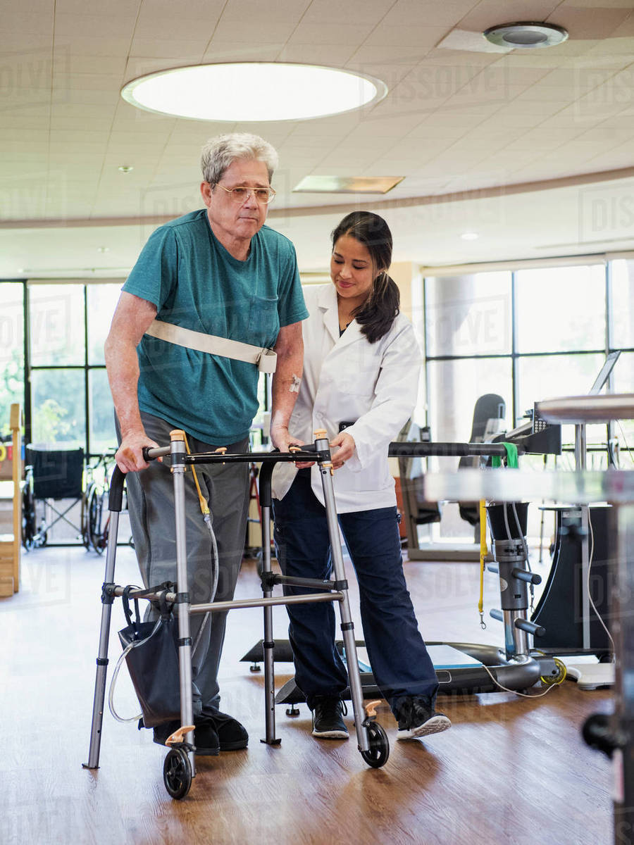 Physical therapist helping man using walker - Royalty-free Stock Photo ...