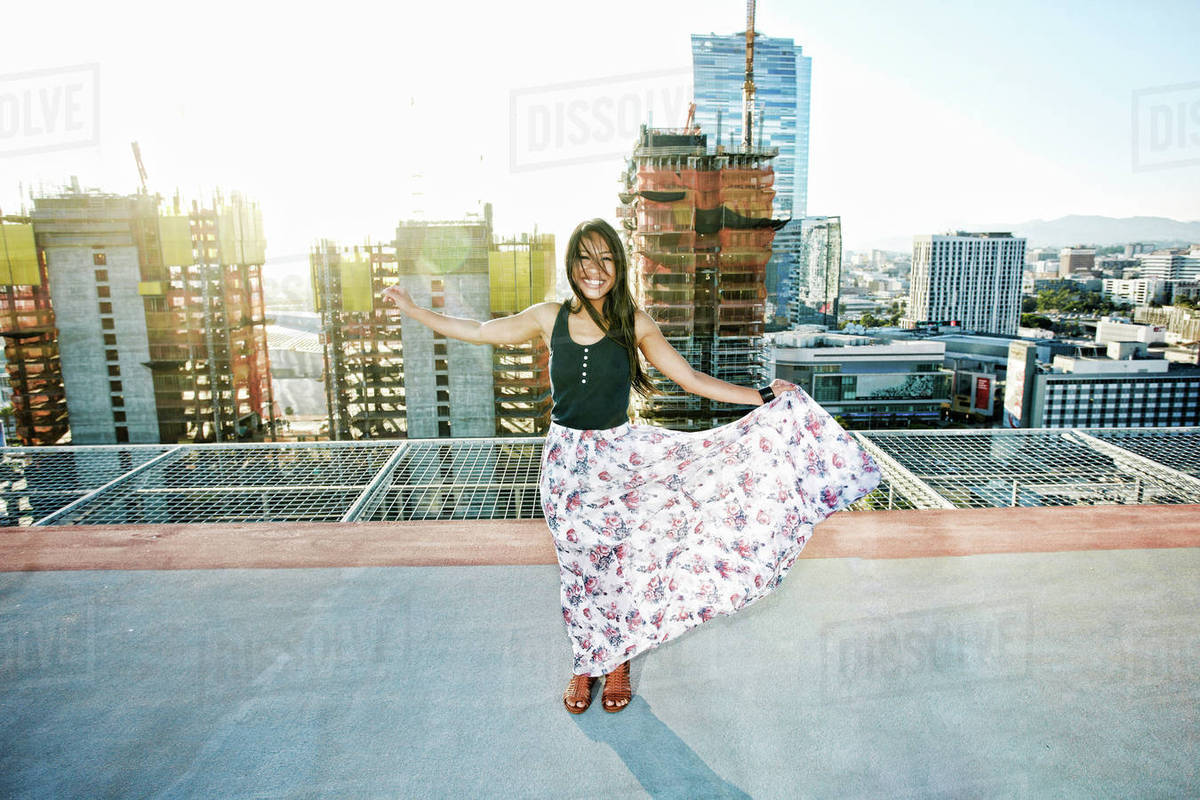 Asian woman dancing on urban rooftop - Royalty-free Stock Photo | Dissolve