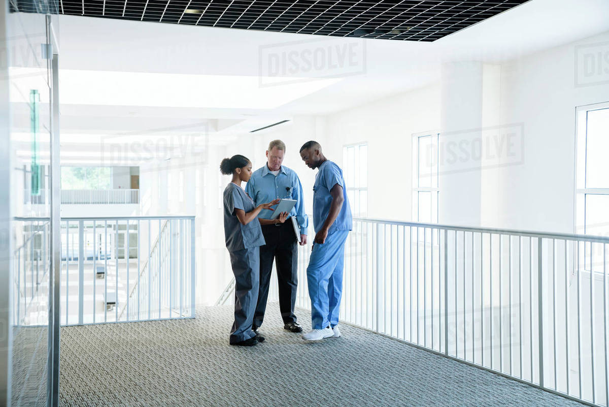 Doctor and nurses discussing digital tablet - Royalty-free Stock Photo ...