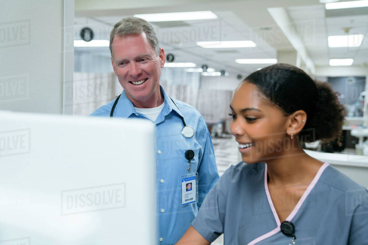 Smiling doctor and nurse using computer - Royalty-free Stock Photo ...