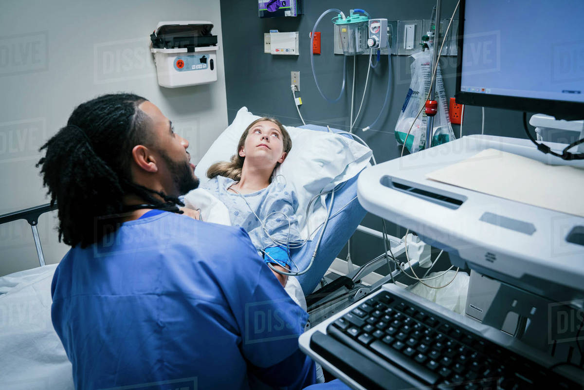Nurse and patient looking at monitor in hospital - Royalty-free Stock ...