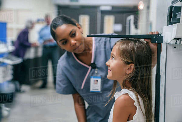 Nurse measuring height of girl in hospital - Royalty-free Stock Photo ...