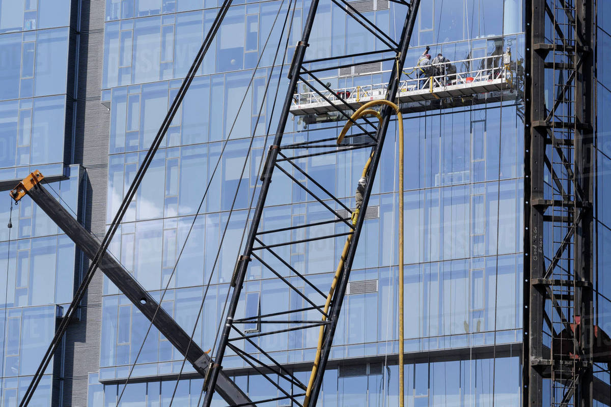 Highrise window washers on scaffolding - Stock Photo - Dissolve