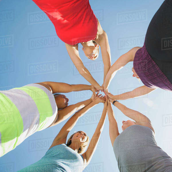 Women putting hands together outdoors - Royalty-free Stock Photo | Dissolve