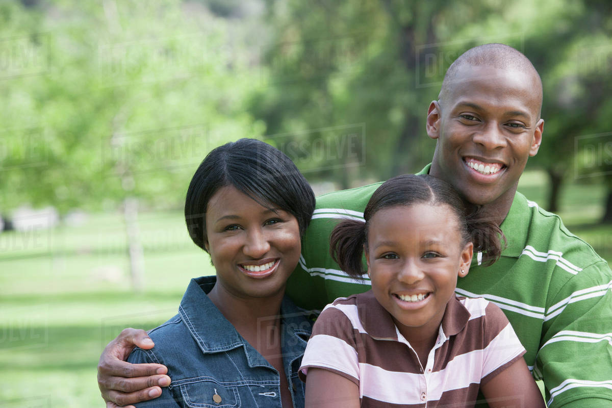 Family smiling together in park - Royalty-free Stock Photo | Dissolve