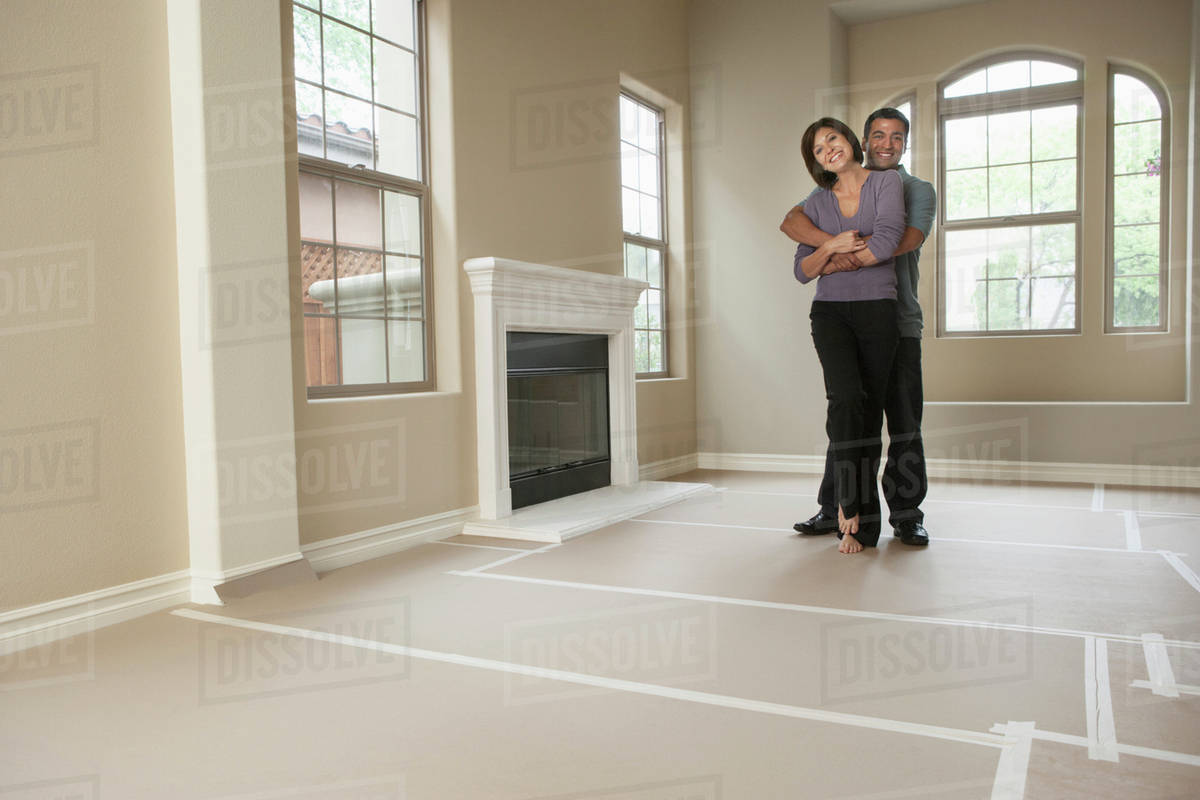 Couple hugging in new home - Stock Photo - Dissolve