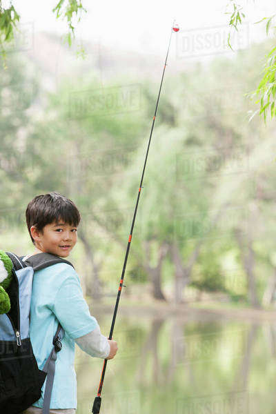 Asian boy carrying fishing pole by lake - Royalty-free Stock Photo ...