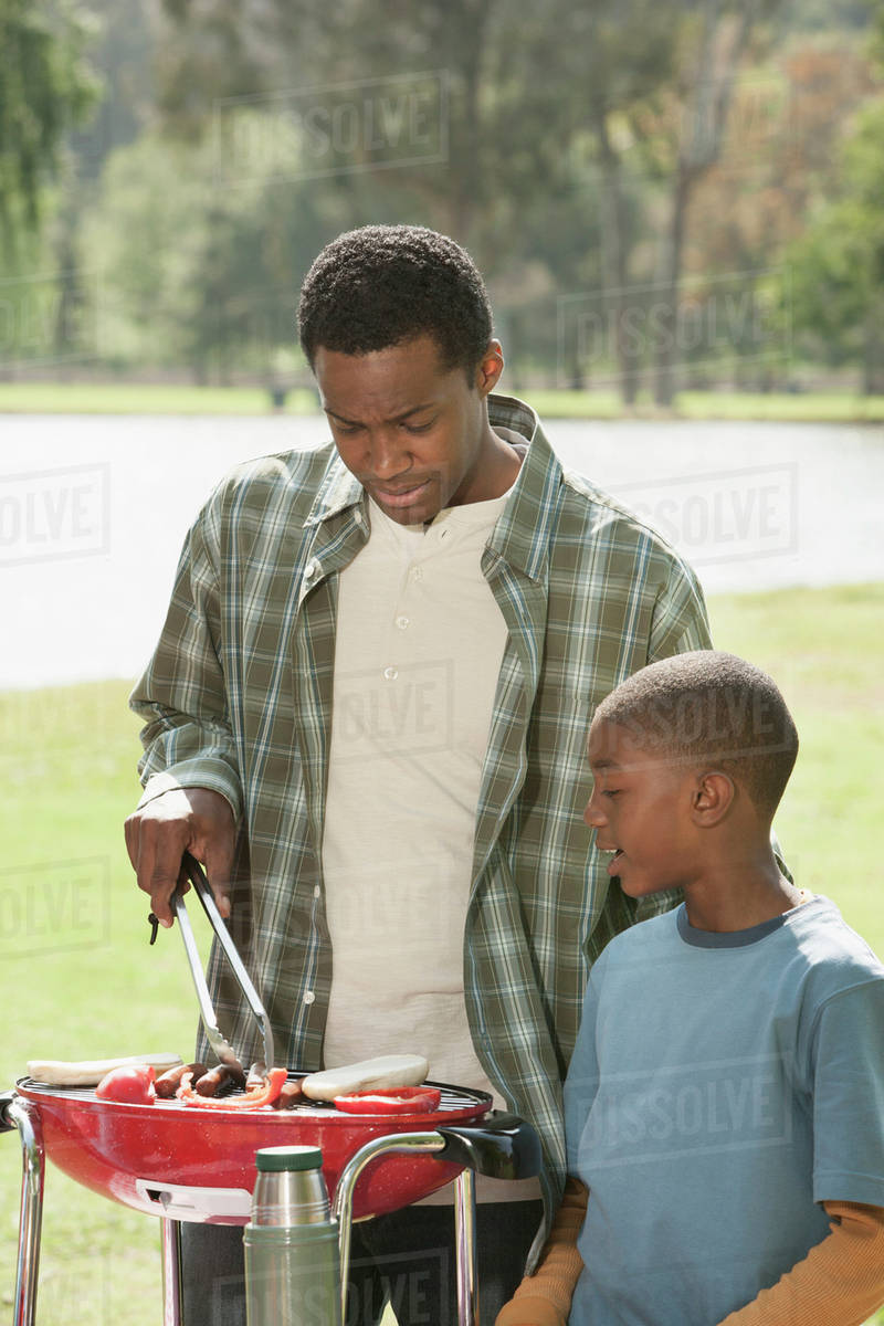 Father and son cooking at picnic table - Royalty-free Stock Photo ...