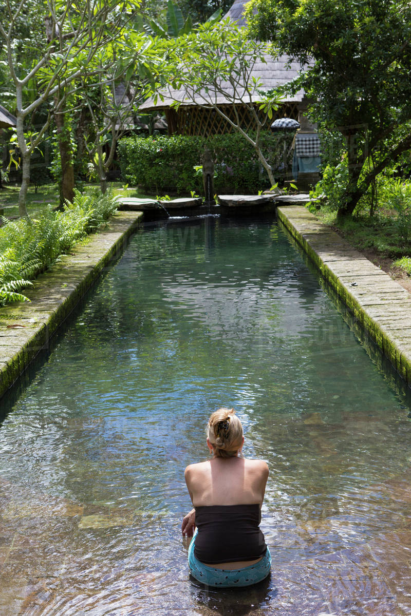Caucasian woman sitting in modern pool - Royalty-free Stock Photo ...