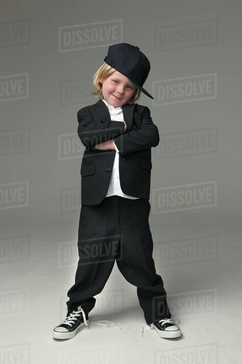 Caucasian boy posing in oversized suit - Stock Photo - Dissolve