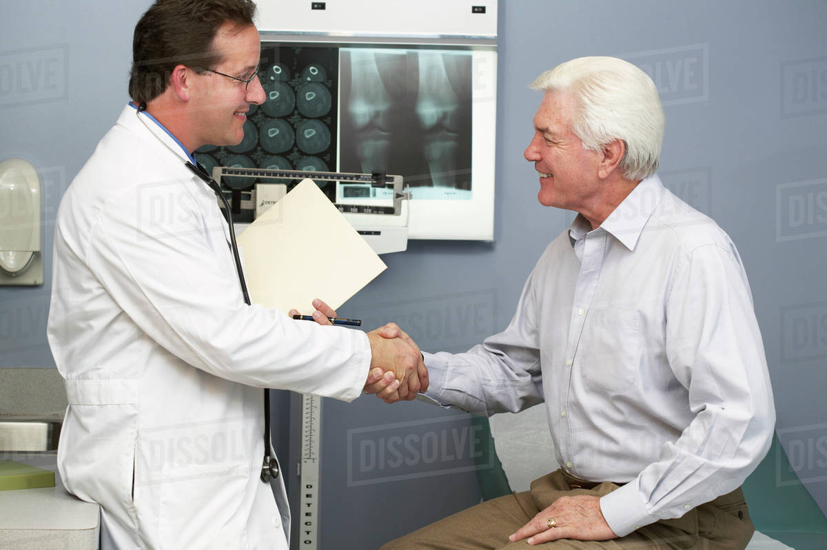 Doctor shaking patient's hand in hospital room - Royalty-free Stock ...