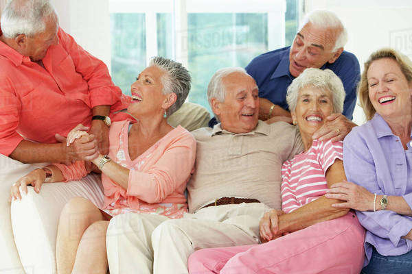 Senior friends talking in living room - Royalty-free Stock Photo | Dissolve