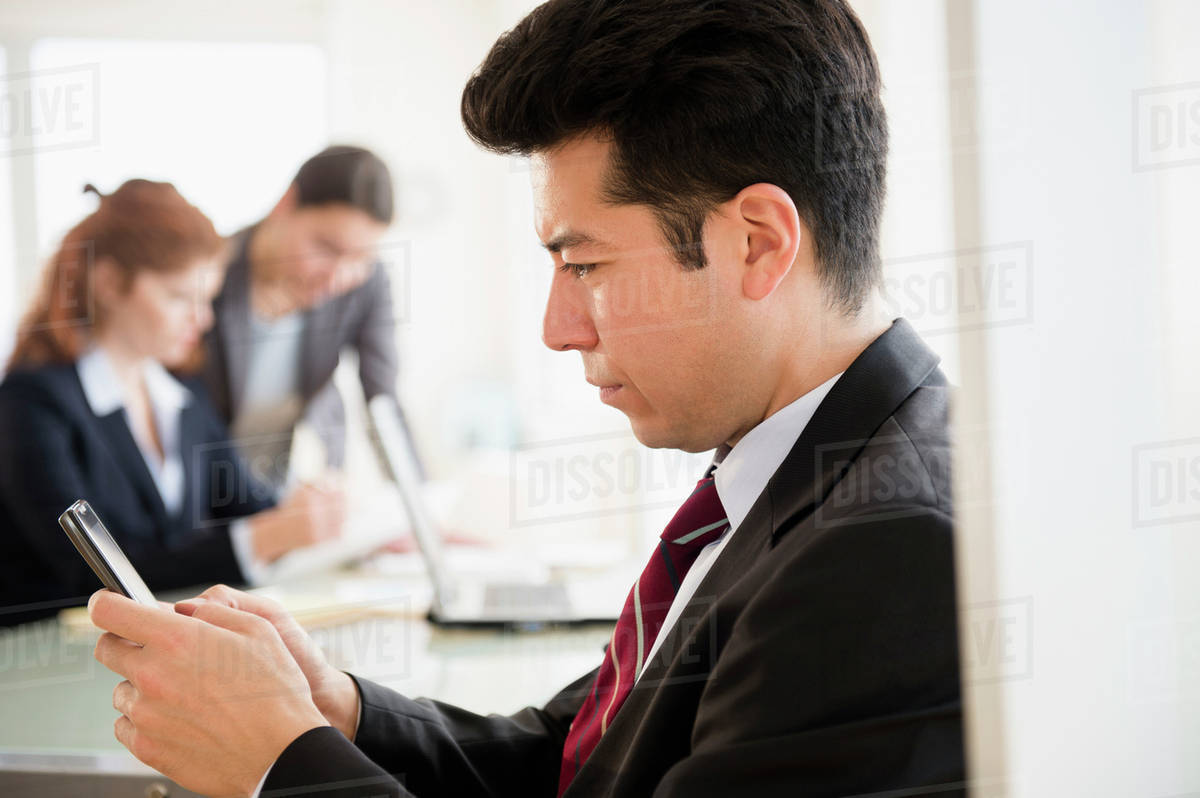 Businessman using cell phone in office - Royalty-free Stock Photo ...